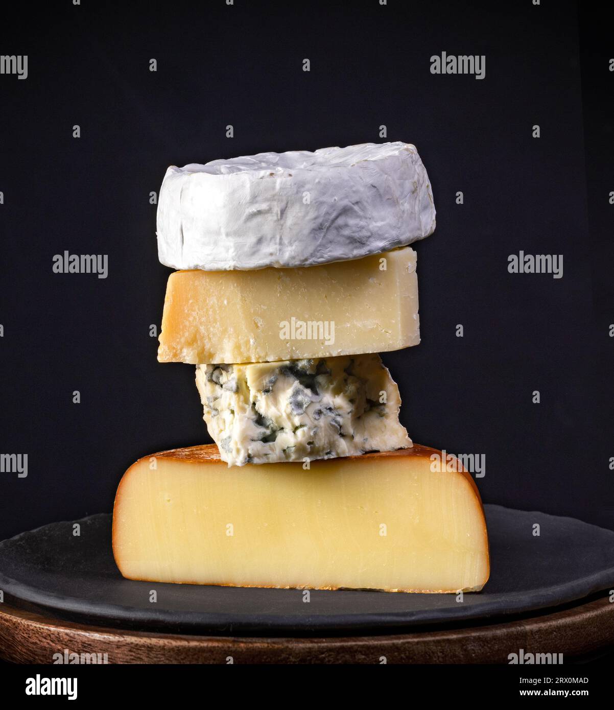 stack of various cheese pieces on black background Stock Photo - Alamy
