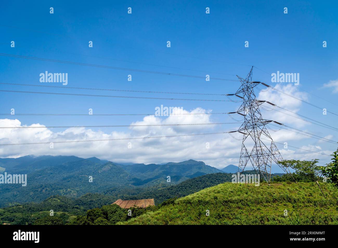 High voltage power, electrical lines running down valley landscape with ...
