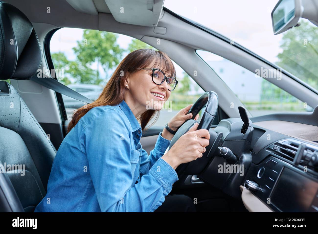 Middle-aged woman driver sitting behind wheel in car Stock Photo - Alamy