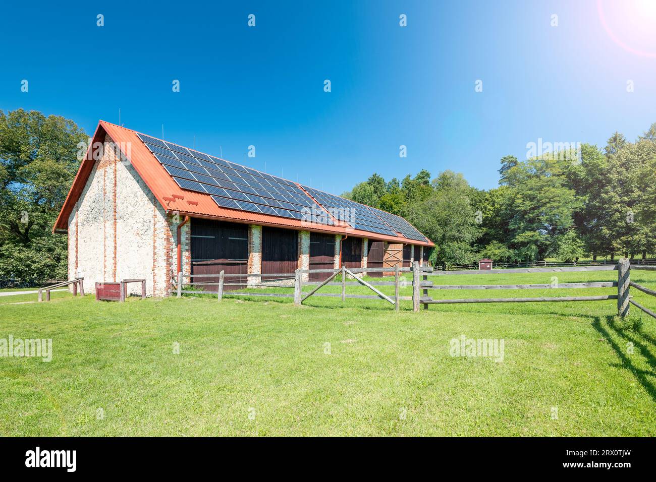 Big brick barn on a farm. Solar panels installed on the roof of the ...