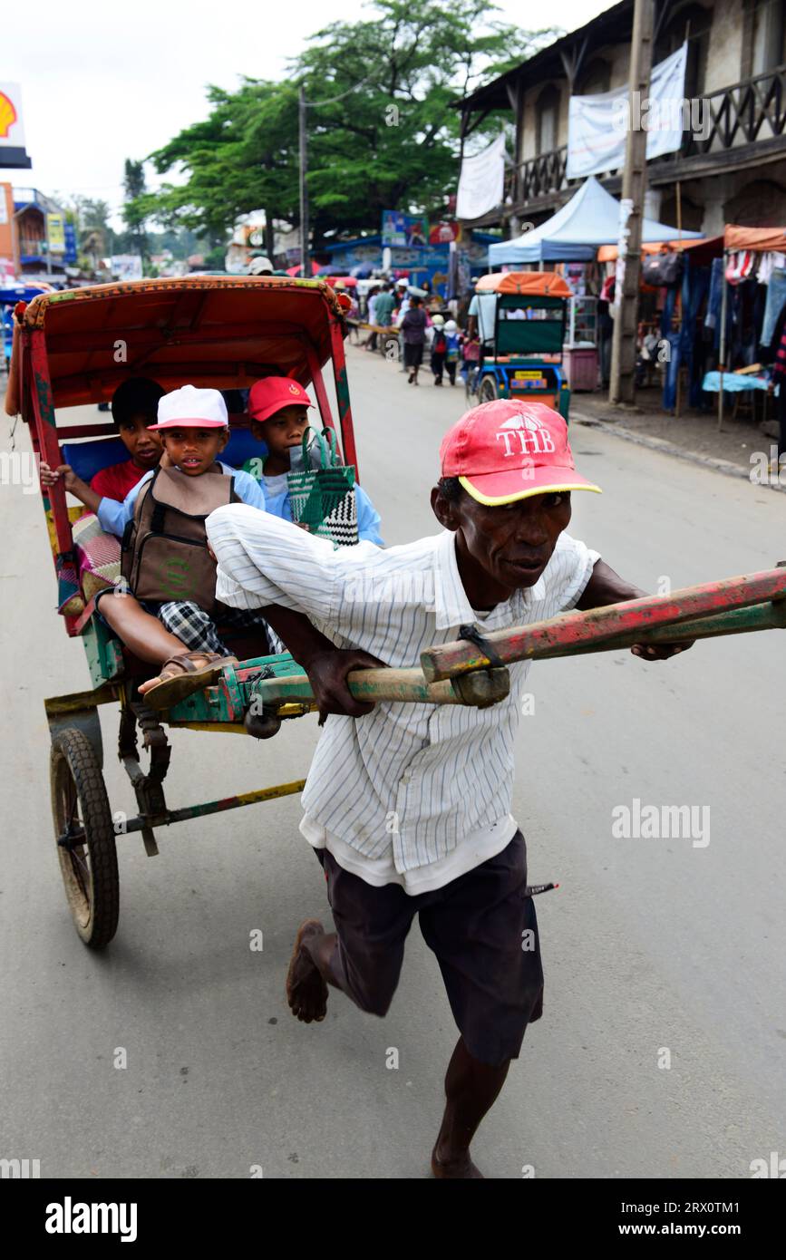Malagasy primary school children going to school in a pousse pousse in ...