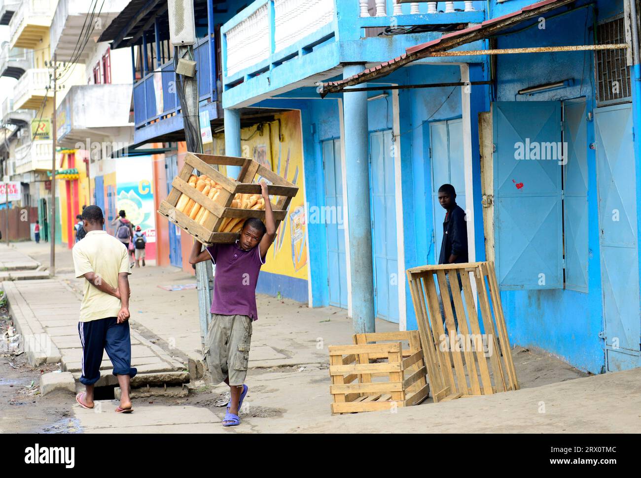 A Malagasy man carrying freshly baked French baguettes in Moramanga ...