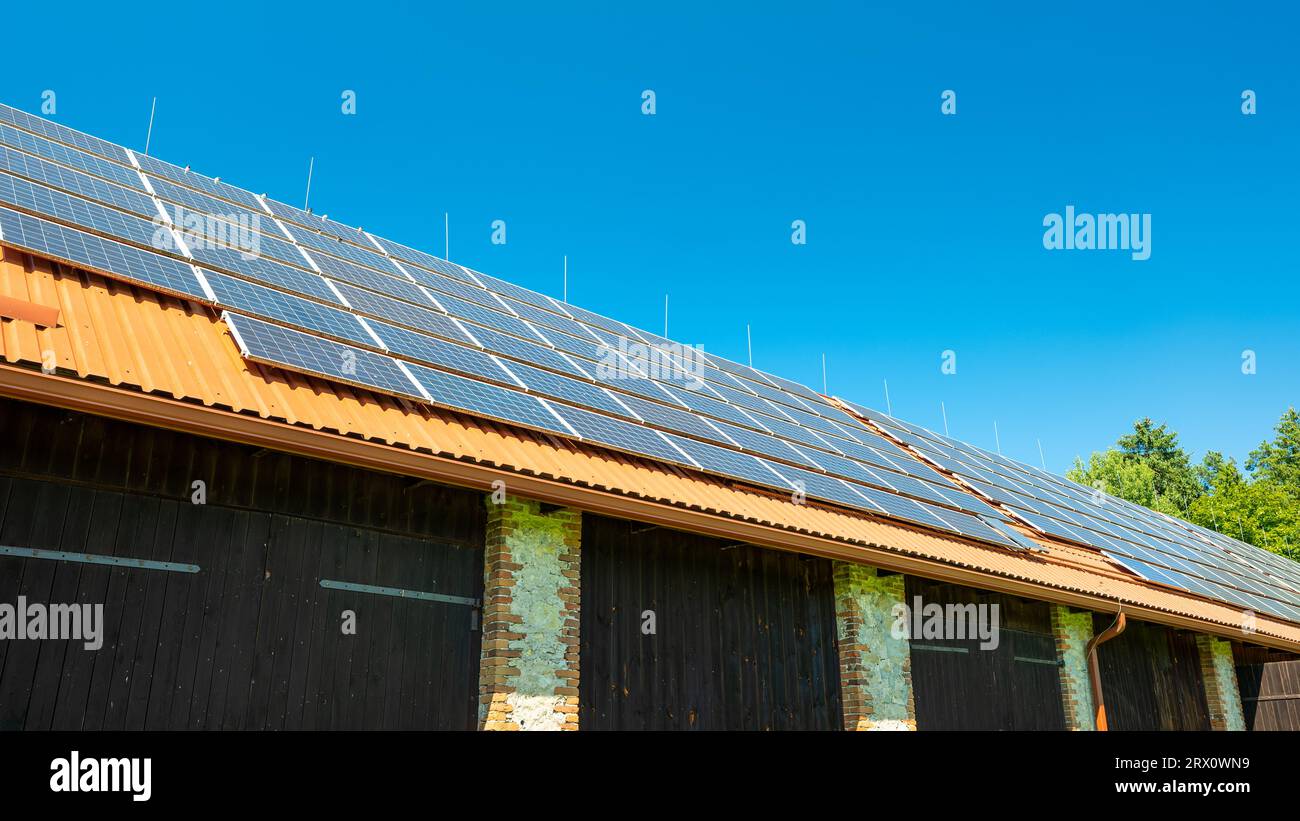 Big brick barn on a farm. Solar panels installed on the roof of the ...