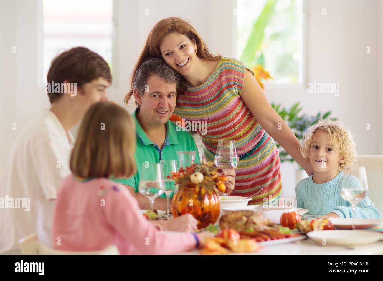 Family with kids eating Thanksgiving dinner. Roasted turkey and pumpkin ...