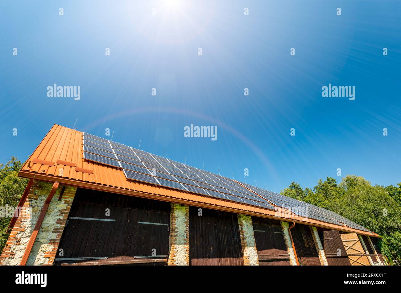 Big brick barn on a farm. Solar panels installed on the roof of the ...