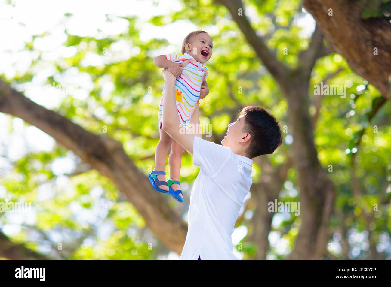 Teenage Asian boy playing with his baby brother. Brothers have fun in ...