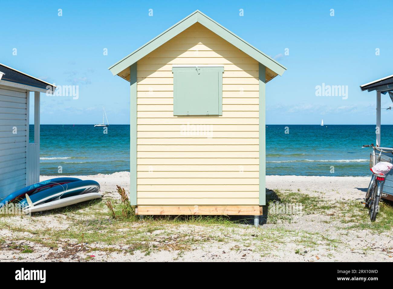Frontal view of the back of a yellow wooden bathing hut on the beach of ...