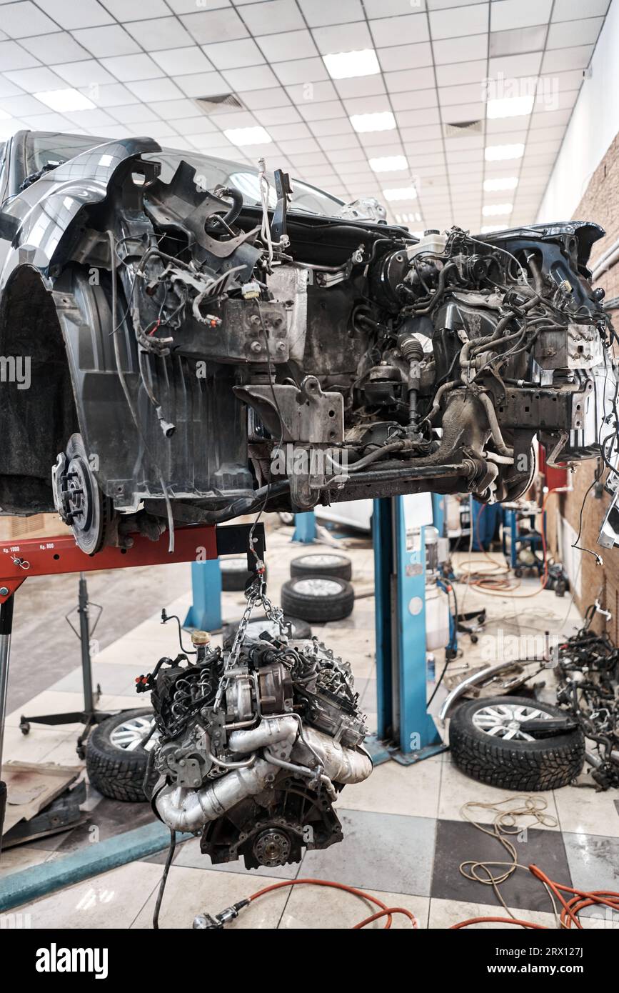 A car mechanic inspects the engine with a flashlight. Engine Block on a ...