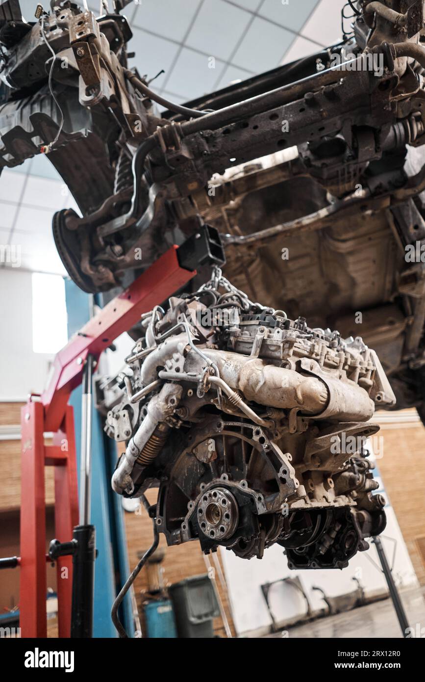 A car mechanic inspects the engine with a flashlight. Engine Block on a ...