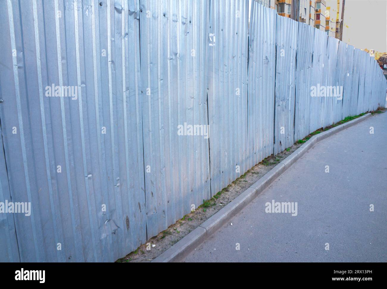 A metal fence along the sidewalk. Fences of the construction site ...