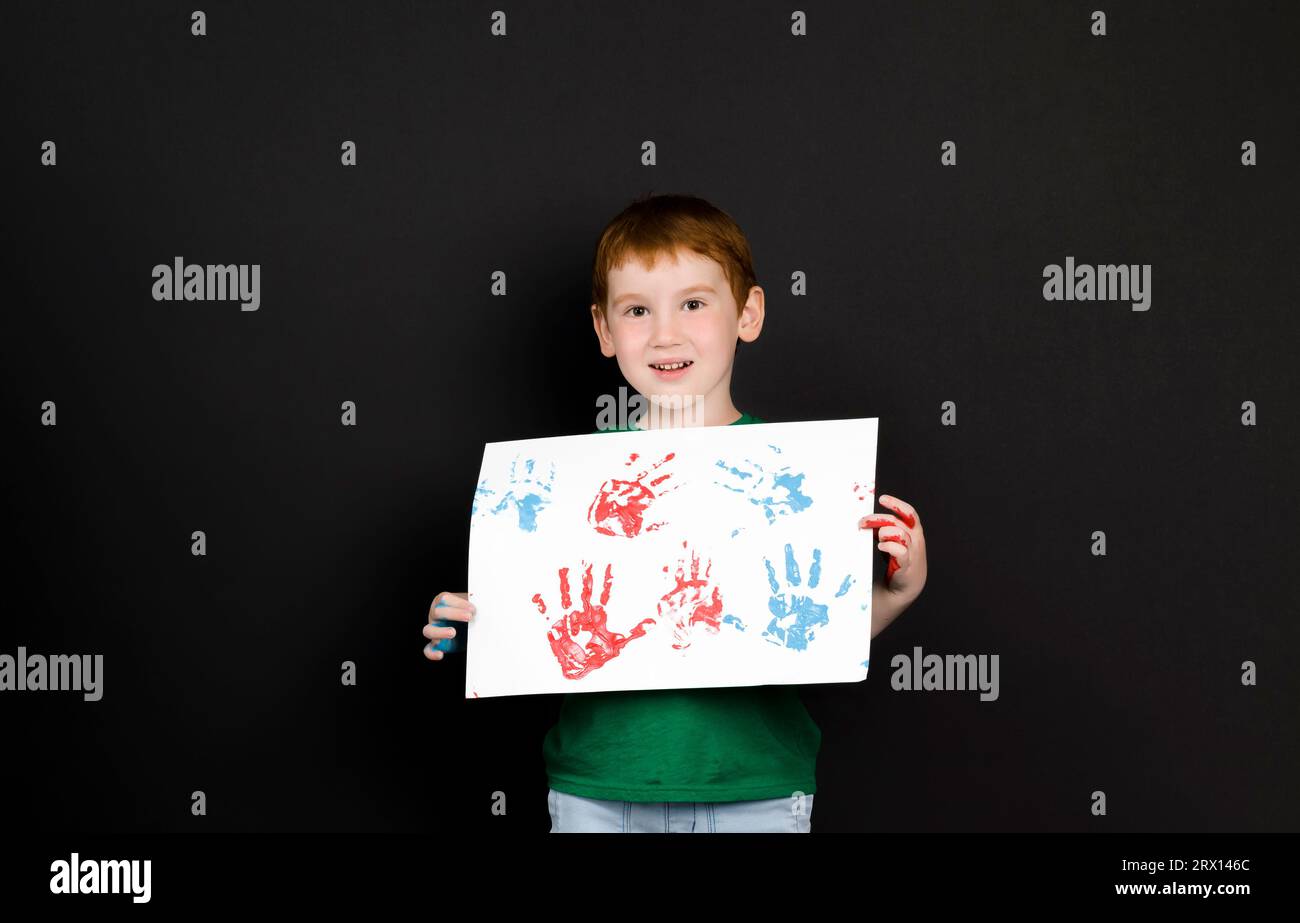 the child's fingerprints on a white sheet of paper while drawing with ...
