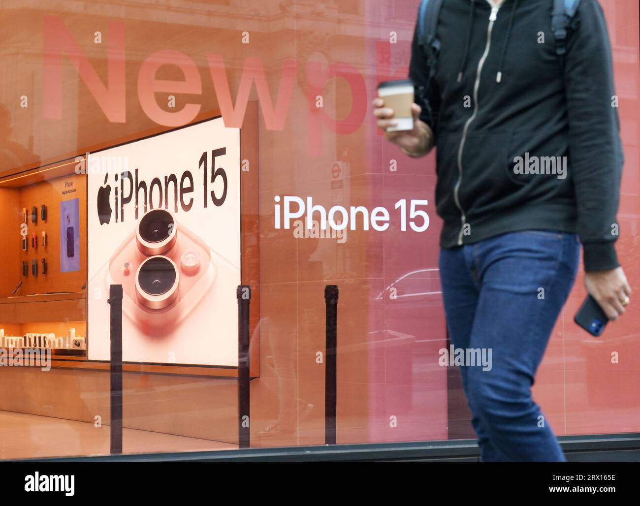 A pedestrian walks past signage heralding the launch of the Apple ...