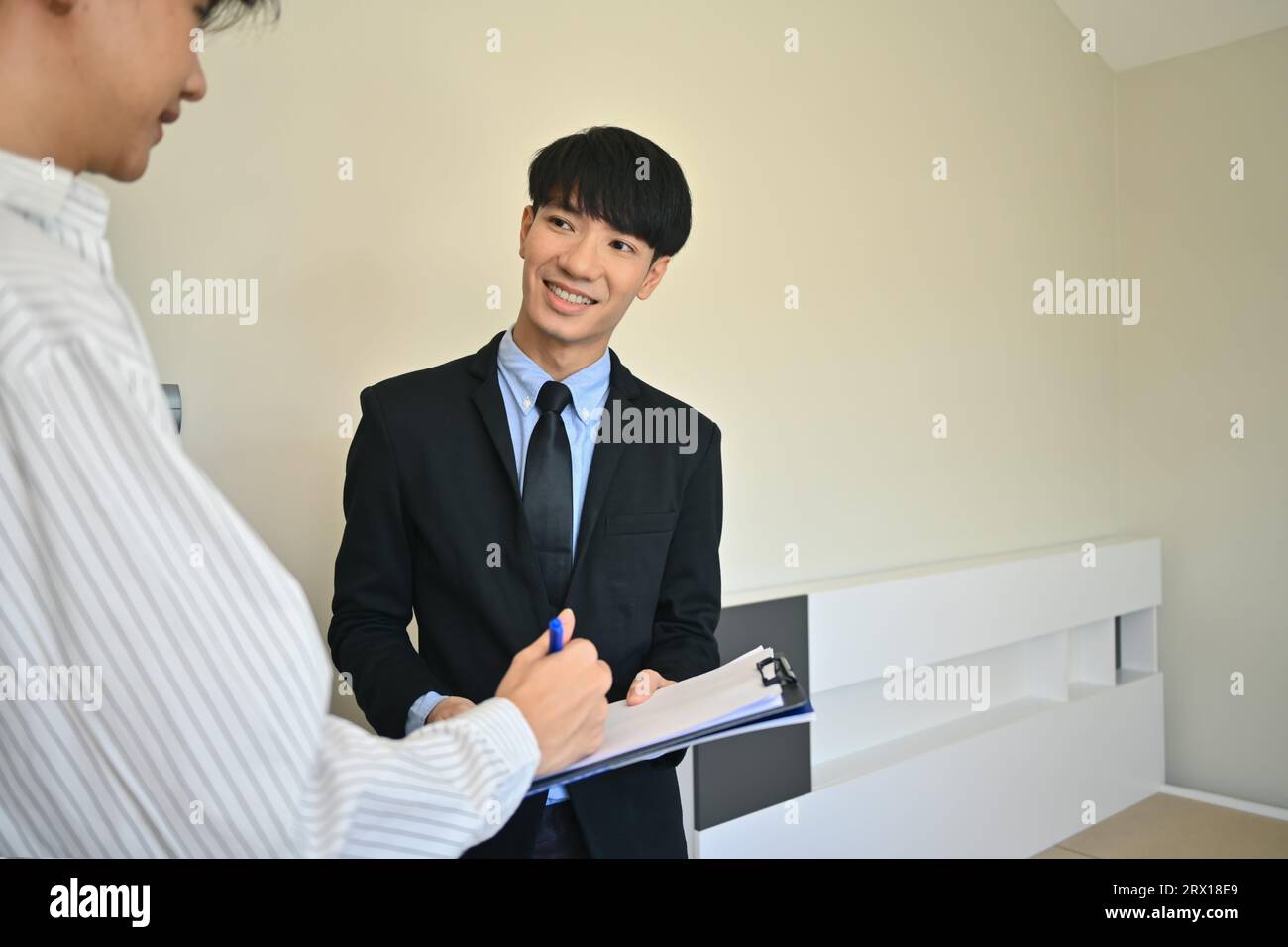 Friendly real estate agent having consultation with young man clients ...