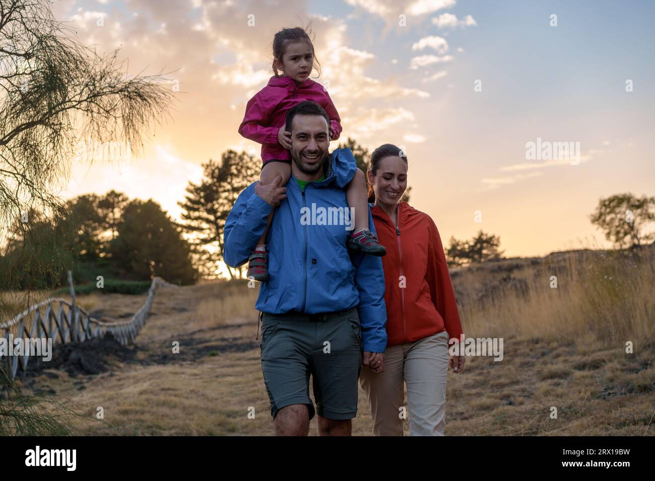 Close-up of a Mediterranean family during a sunset mountain walk. The ...
