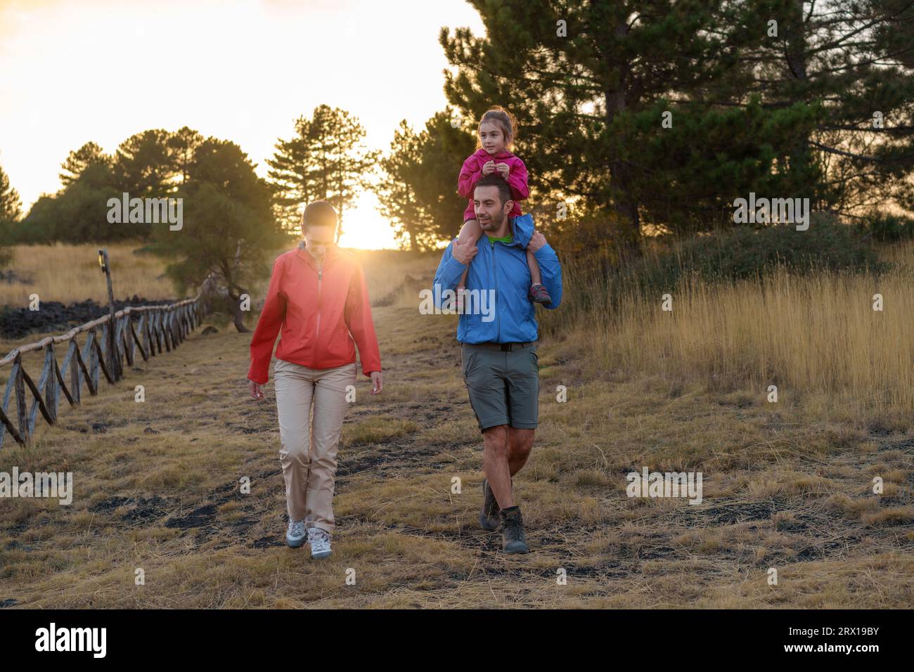 A Mediterranean family walks a mountain path at sunset. The silhouette ...