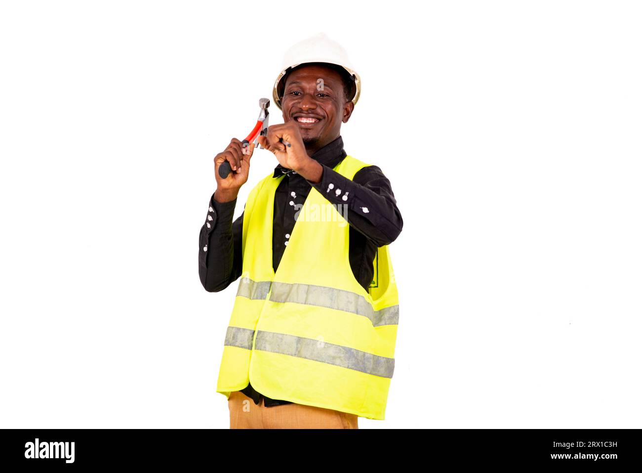 young man engineer wearing a green vest driving a nail into the void ...