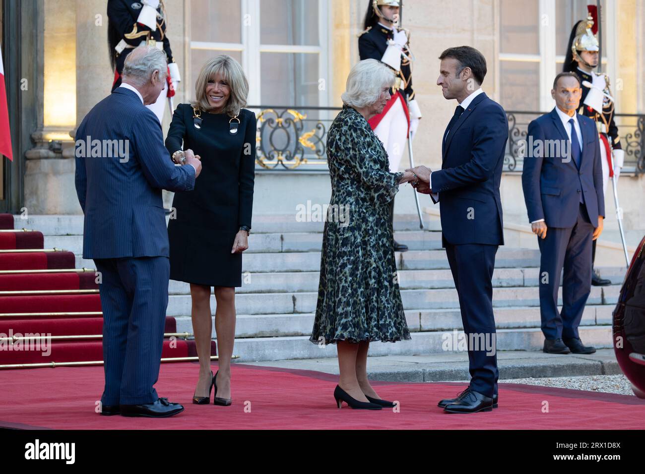 French President Emmanuel Macron kisses Britain Queen Camilla next to ...
