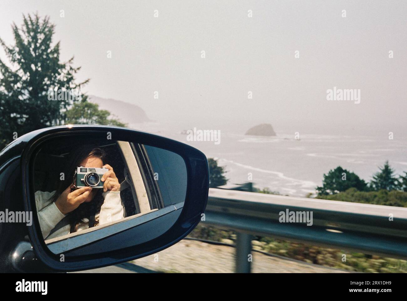 Woman taking a mirror selfie with a vintage film camera on the p Stock ...