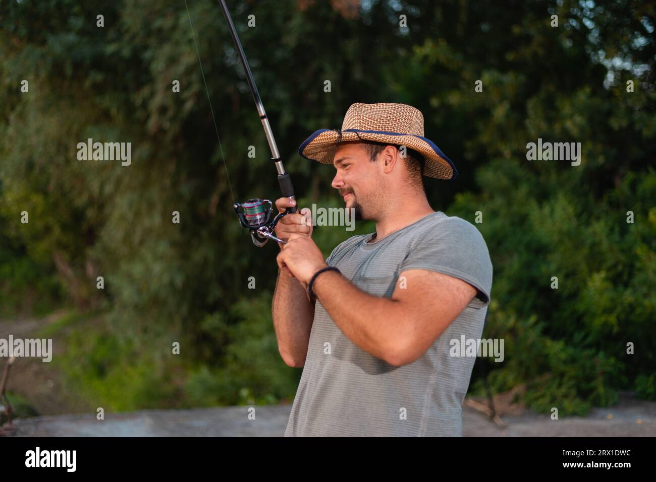 Young man pulling out fish from the river Stock Photo - Alamy