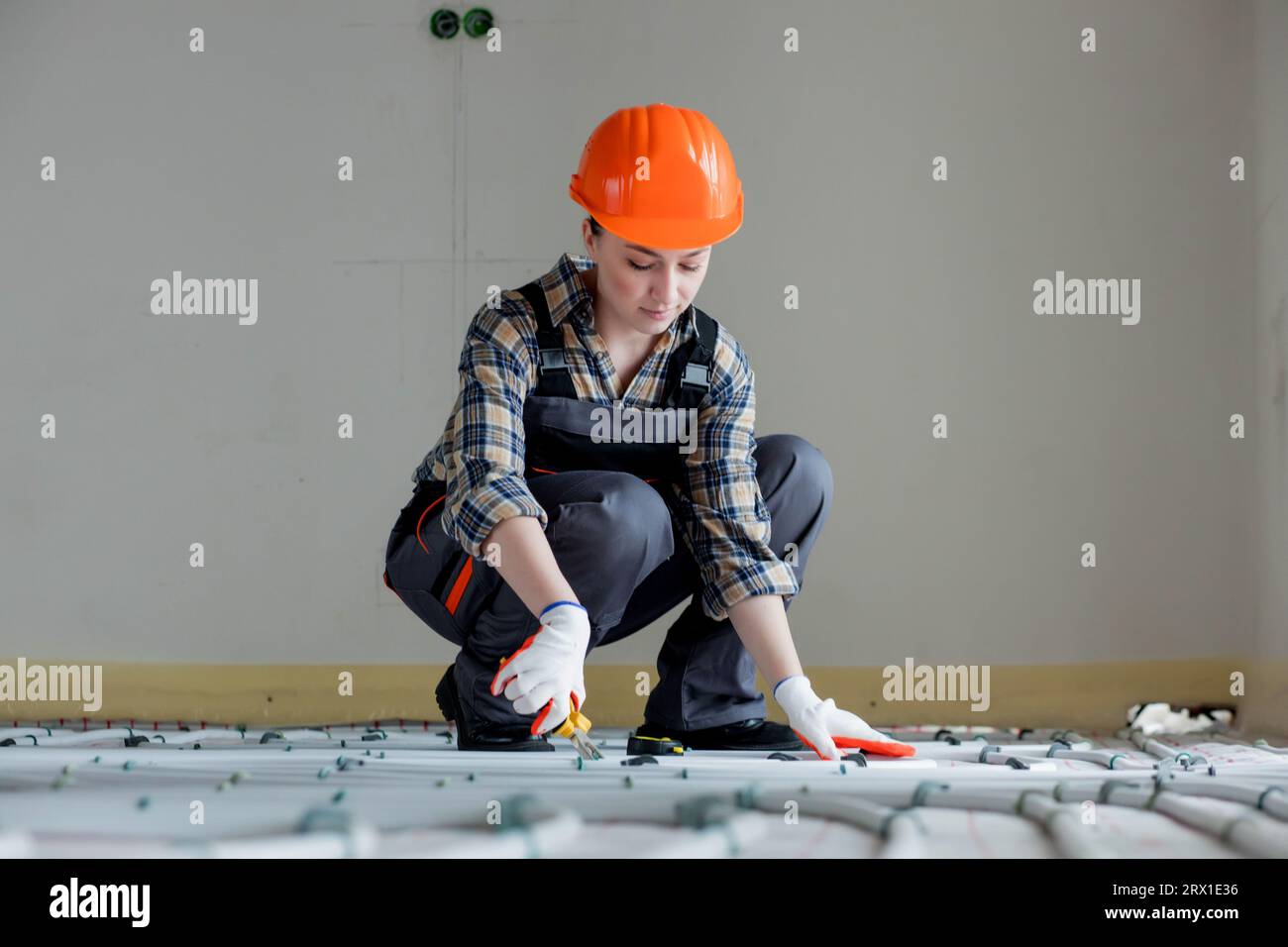 Woman worker is installing underfloor heating system. Warm floor ...