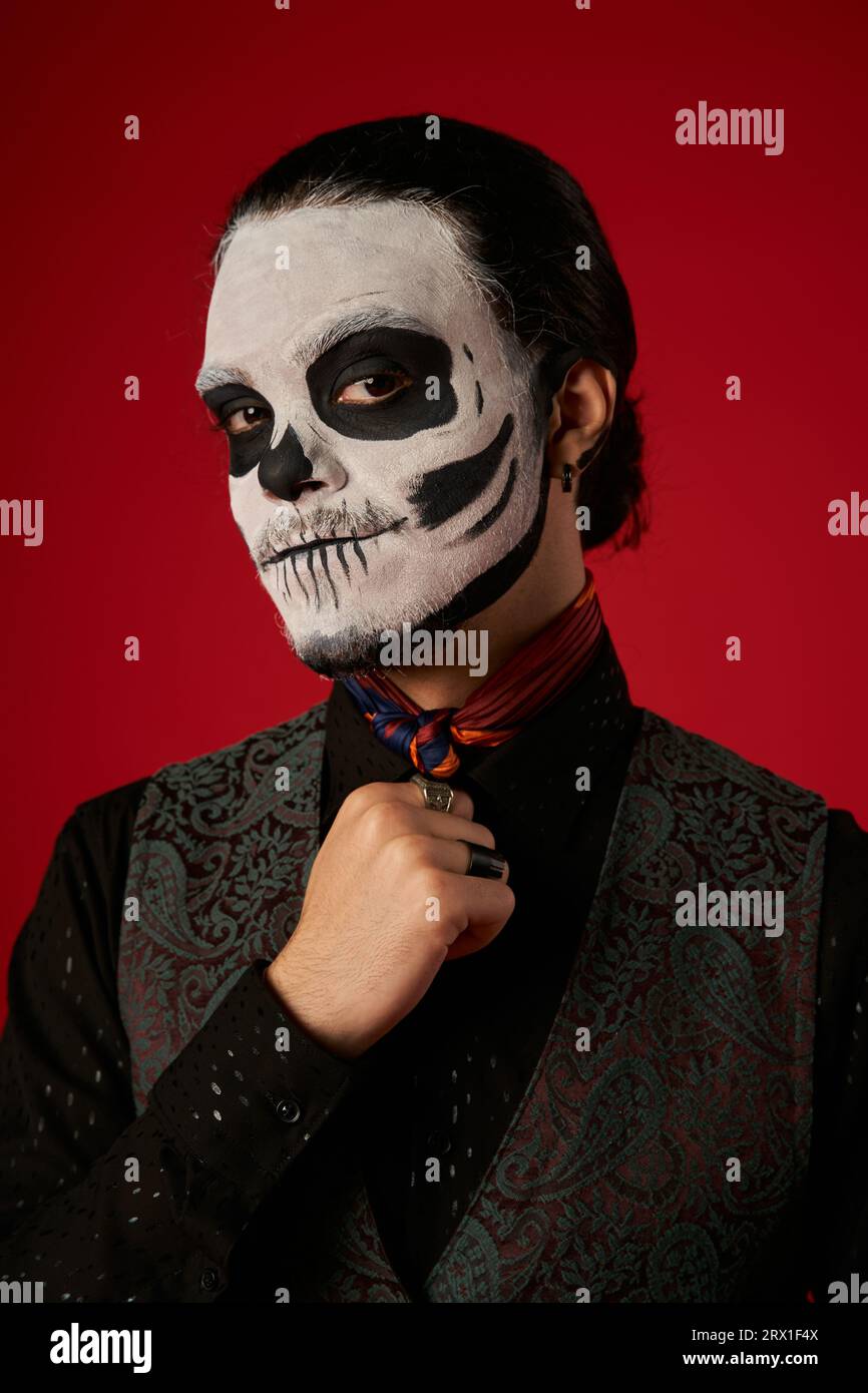 portrait of man in catrina makeup and stylish attire looking at camera ...