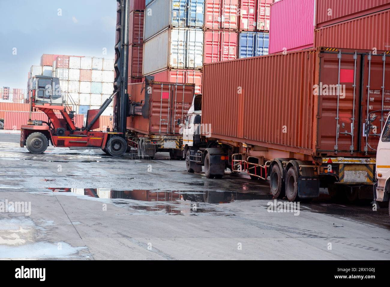A container forklift sits behind a stack of containers Stock Photo - Alamy