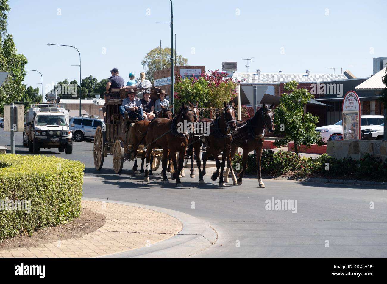 an old Cobb and Co stage coach lead by horses travel down main street ...