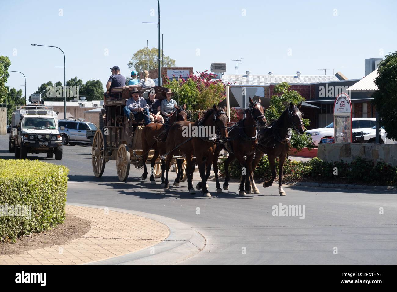 an old Cobb and Co stage coach lead by horses travel down main street ...