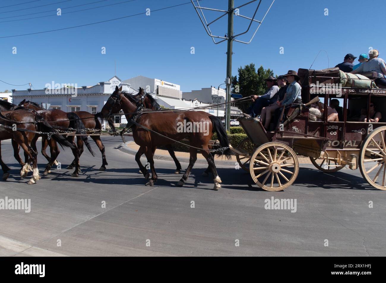 an old Cobb and Co stage coach lead by horses travel down main street ...