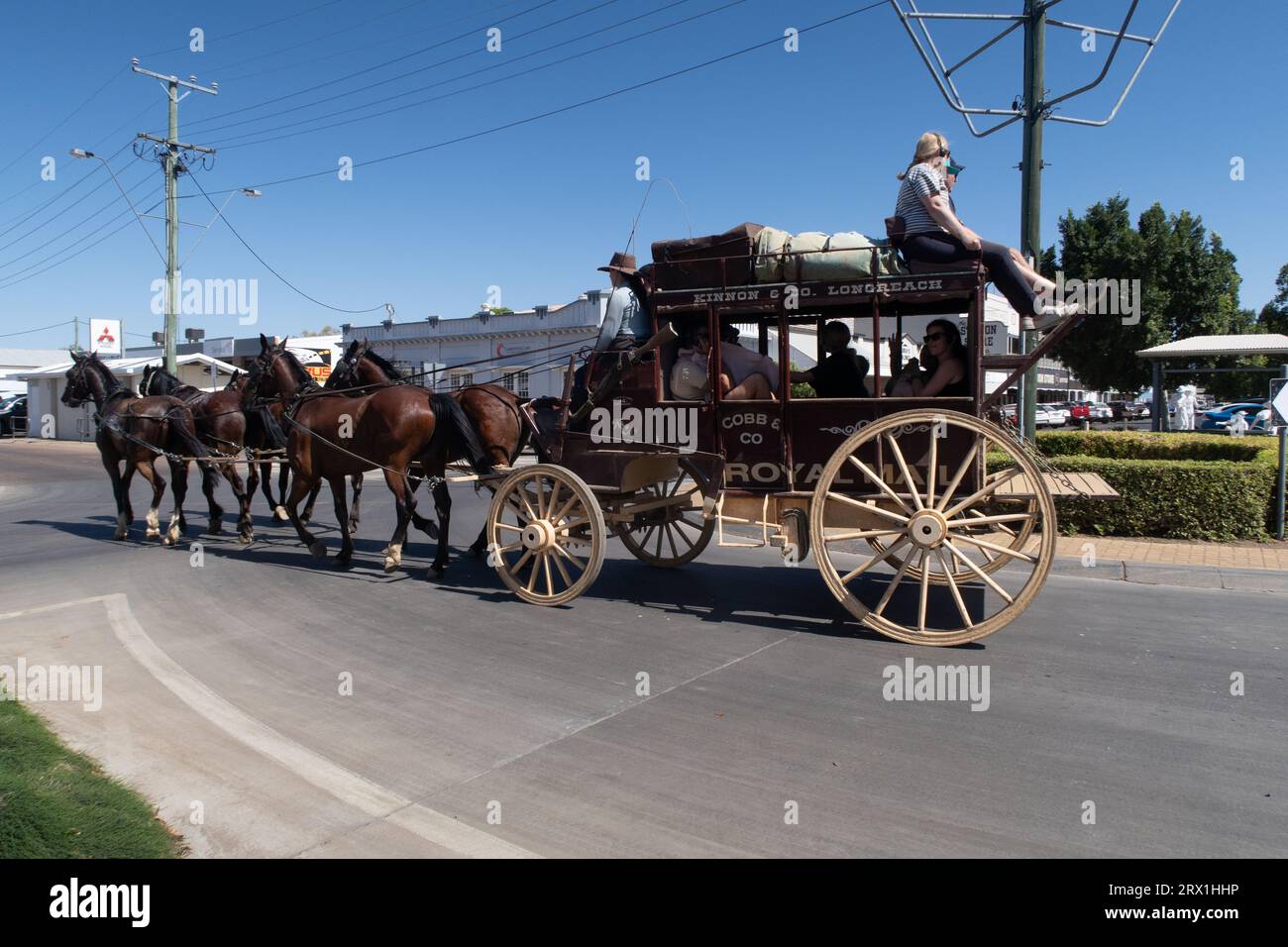 an old Cobb and Co stage coach lead by horses travel down main street ...