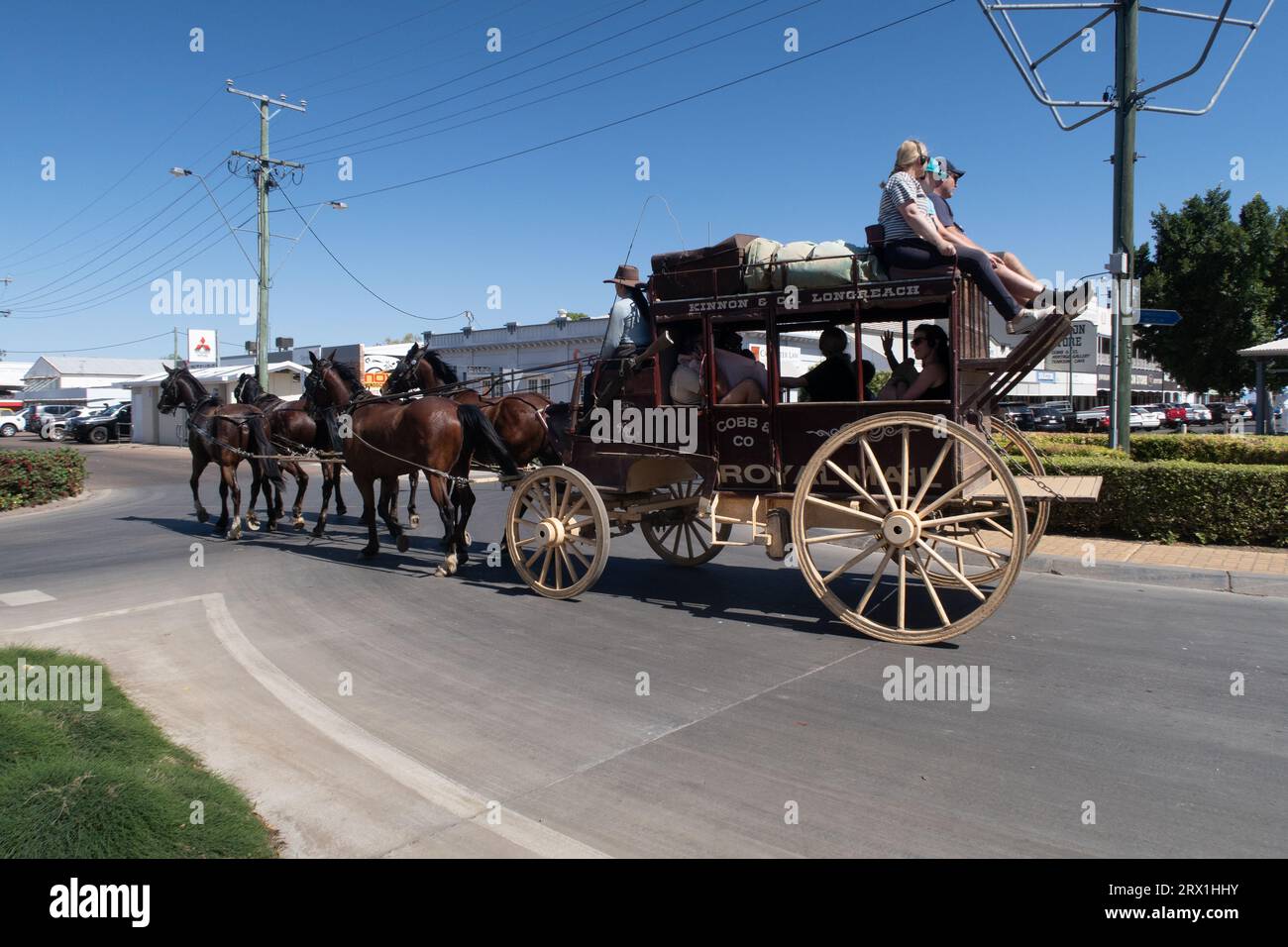 an old Cobb and Co stage coach lead by horses travel down main street ...