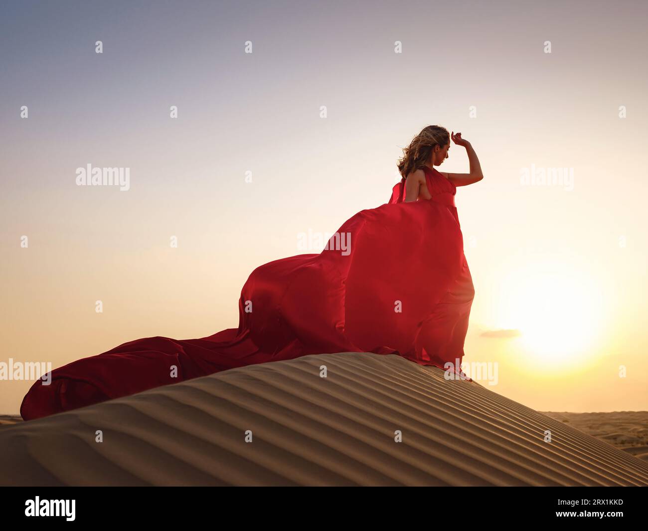 Desert adventure. Young arabian Woman in red silk dress in sands dunes ...