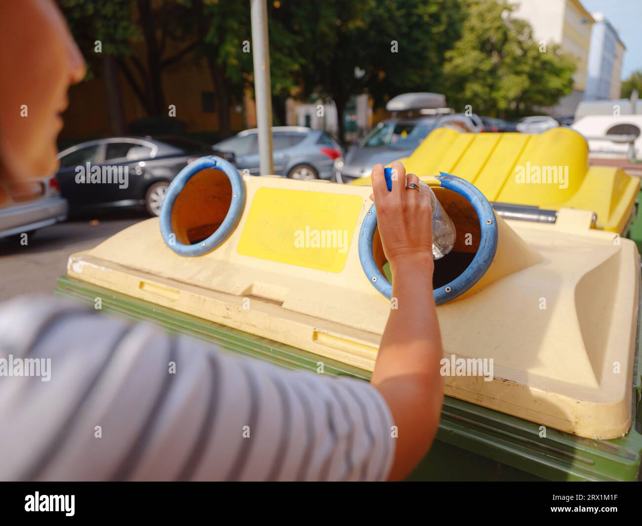 woman throwing plastic bottle Recycling bin stand on european street ...