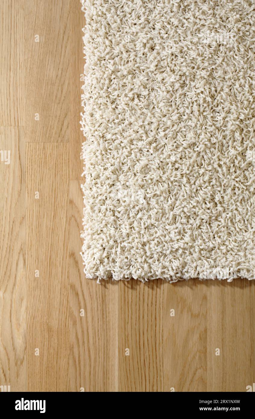 Rug on hardwood oak parquet floor Stock Photo - Alamy