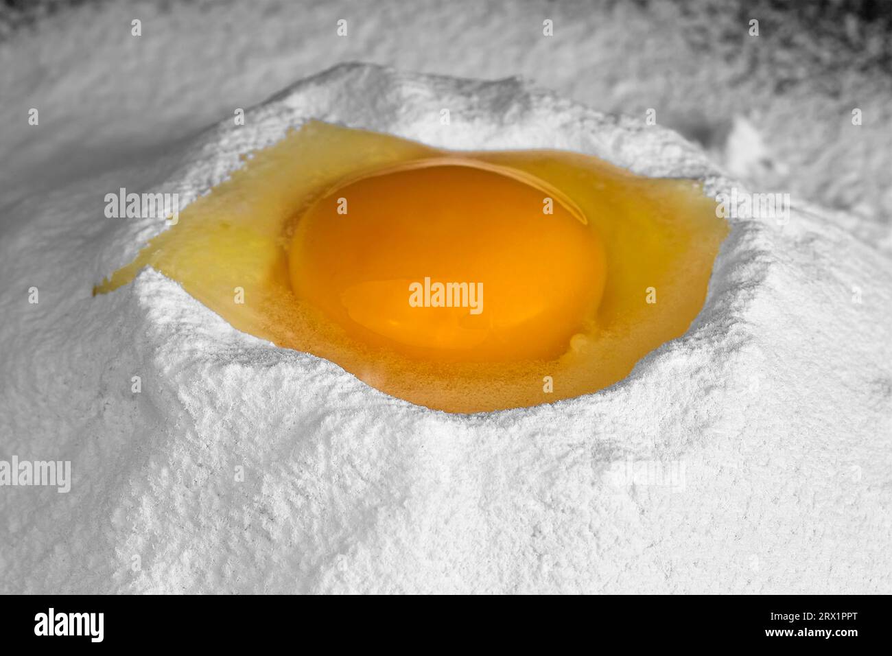 Cracked egg in a hollow of flour, ready for further processing Stock ...