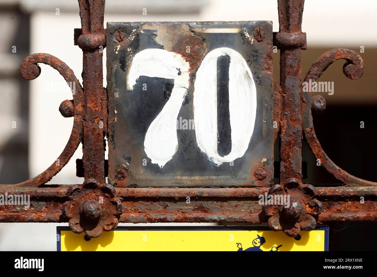 Old weathered house number sign number seventy and decorated metal ...