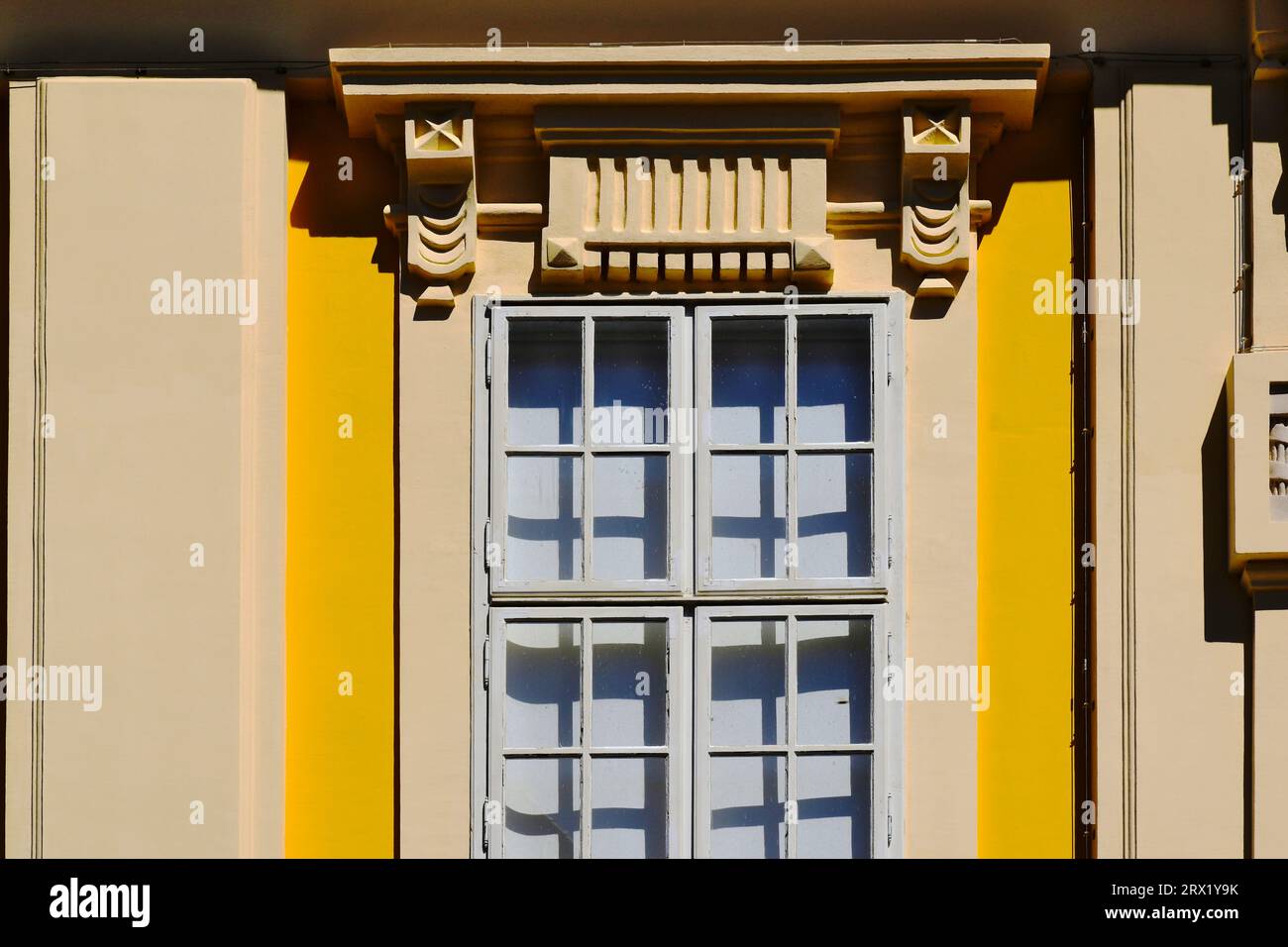 decorative old wood window in yellow stucco exterior wall. ornate ...
