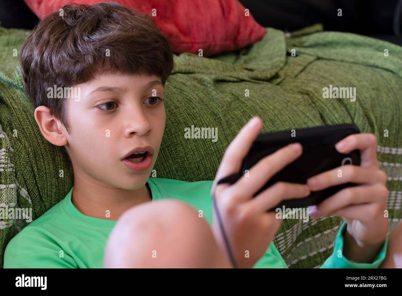 A child looking at his cell phone. concentration on children's games ...
