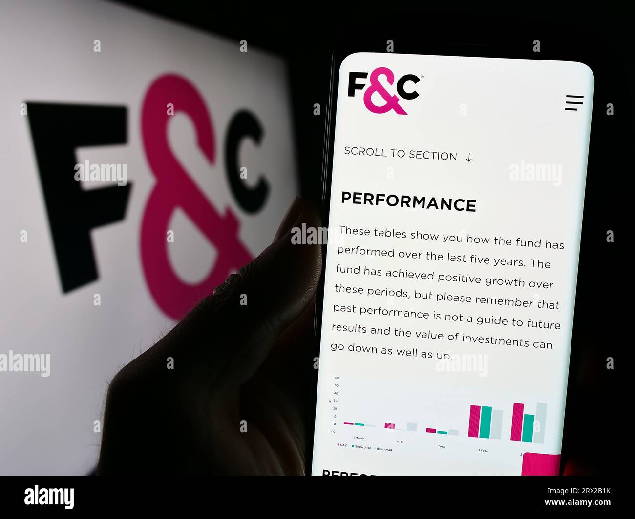 Person holding cellphone with webpage of company Foreign Colonial ...