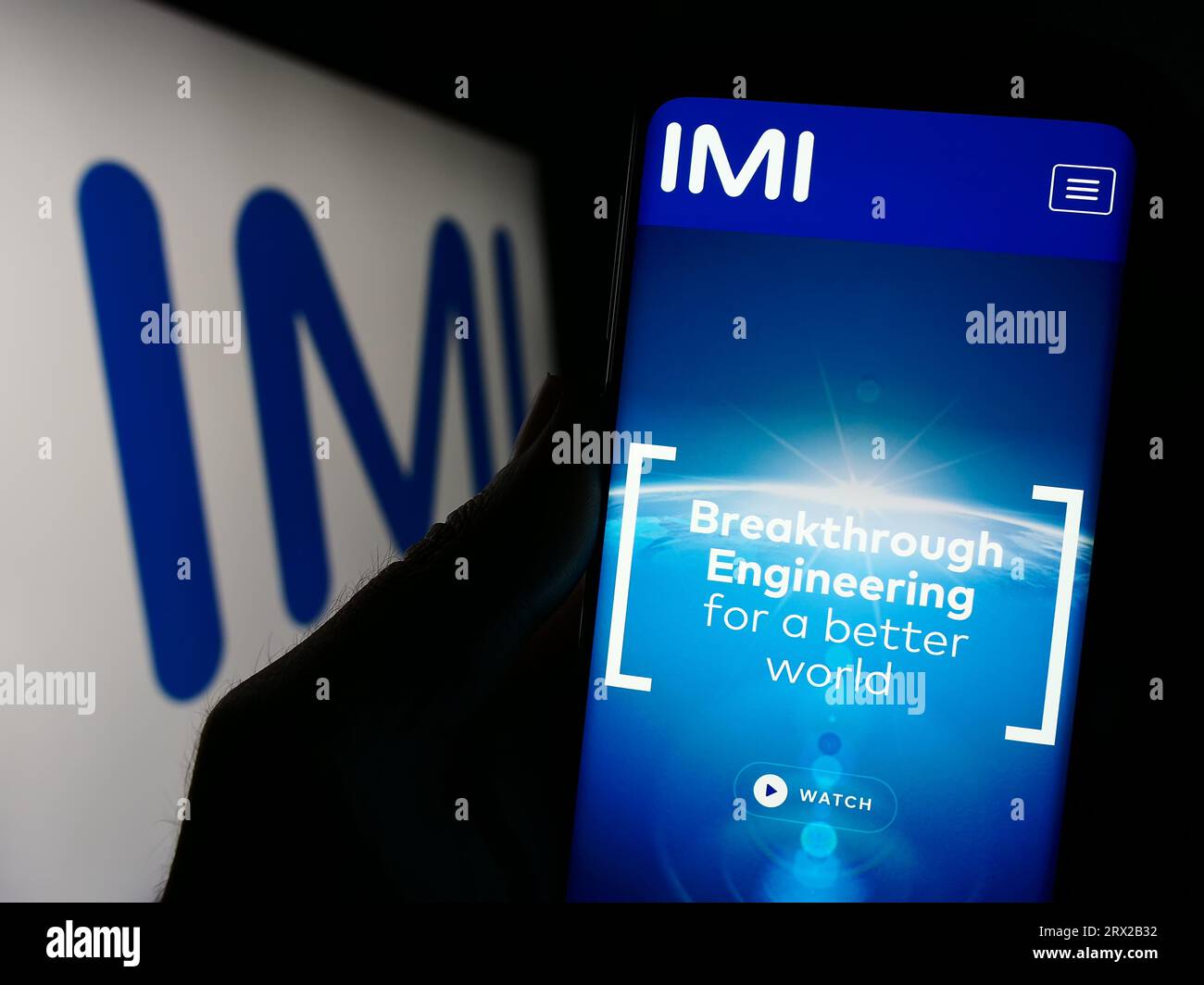 Person holding smartphone with website of British engineering company ...