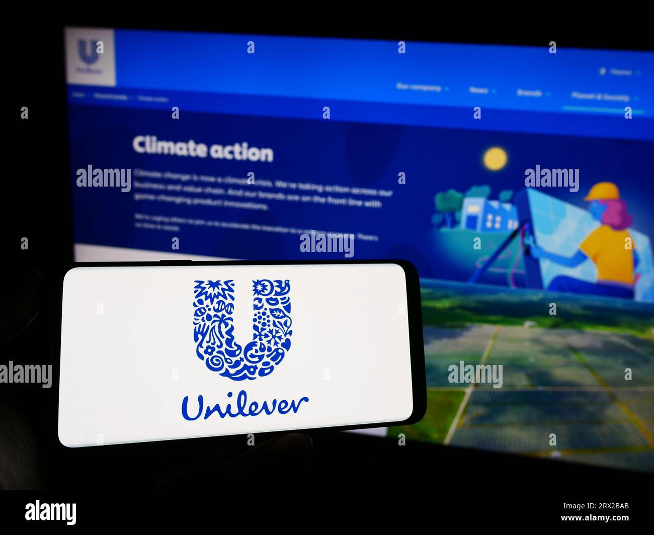 Person holding cellphone with logo of British consumer goods company ...