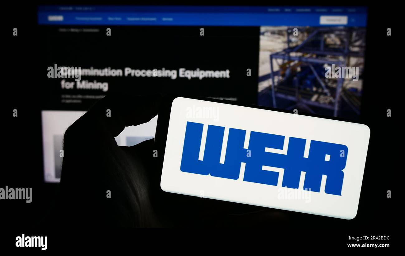 Person holding smartphone with logo of British company The Weir Group ...