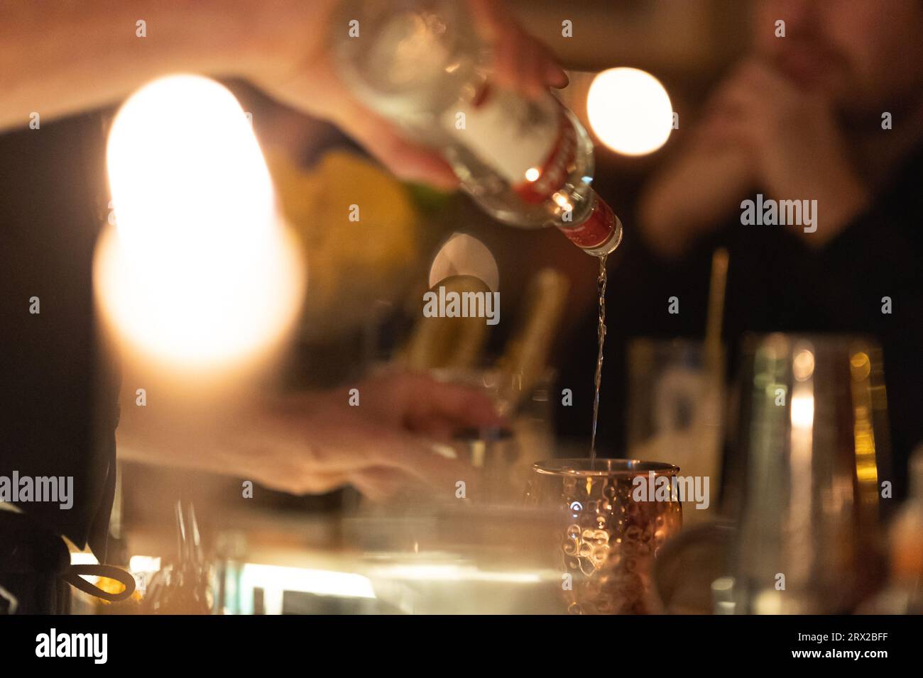 The bartender pouring vodka in the mixer. Mid shot Stock Photo - Alamy