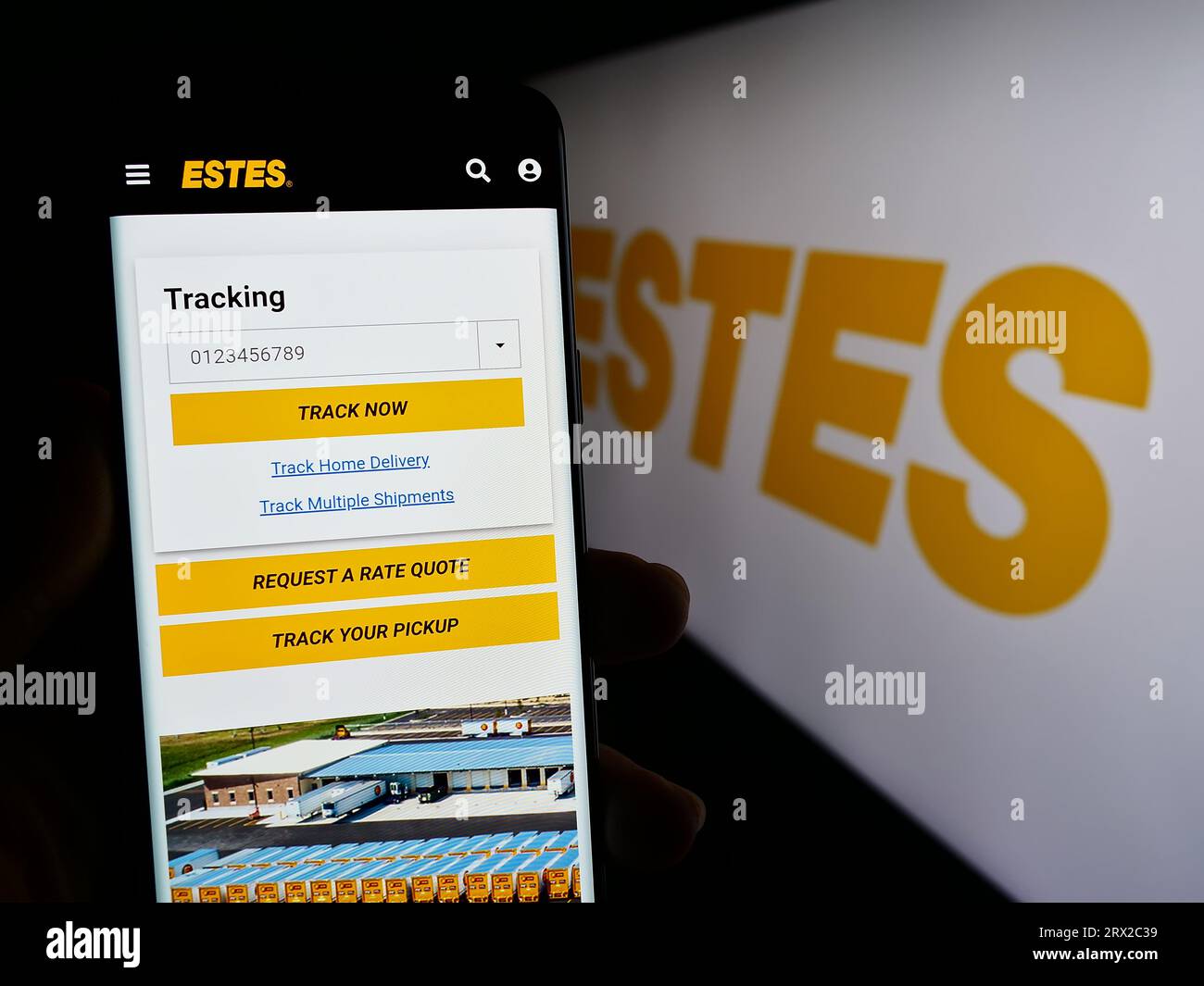 Person holding mobile phone with webpage of US logistics company Estes ...