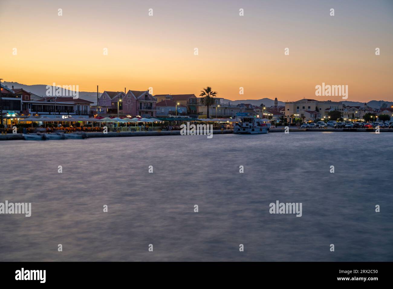 View of town skyline from the harbour at dusk, Lixouri, Kefalonia ...