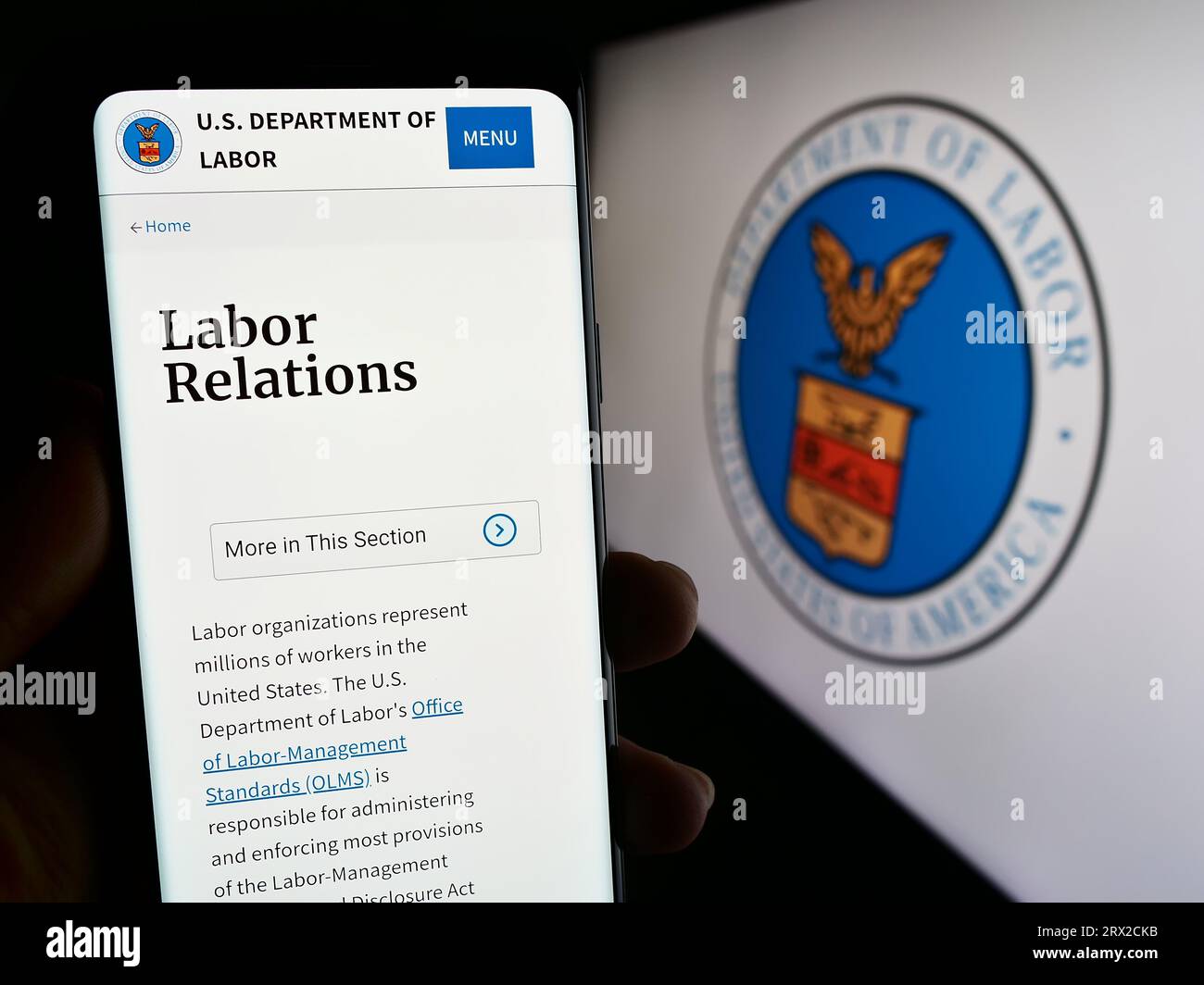 Person holding smartphone with web page of United States Department of ...