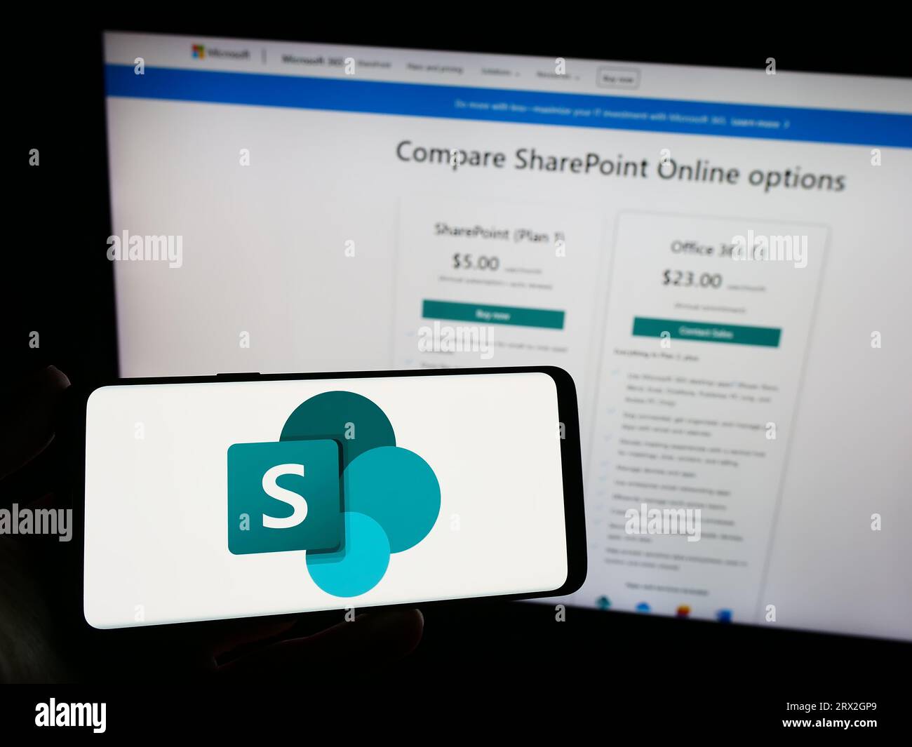 Person holding mobile phone with logo of collaborative platform Microsoft SharePoint on screen ...