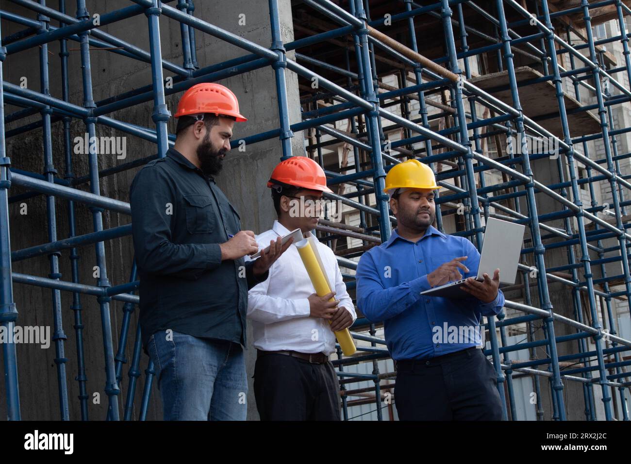 Male engineer using laptop and having a discussion with his colleagues ...