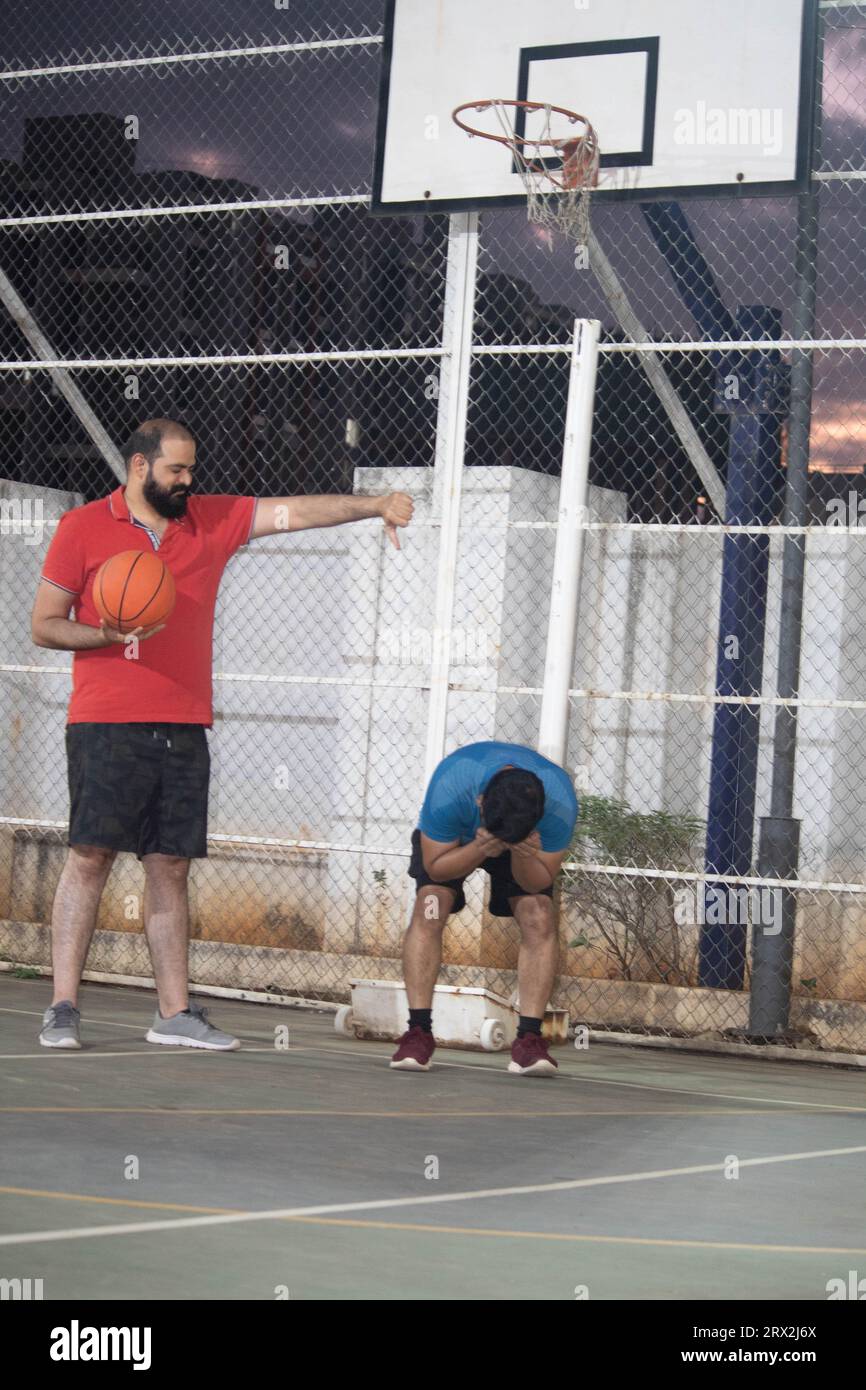 Man showing thumbs down after winning a game of basketball. sad ...