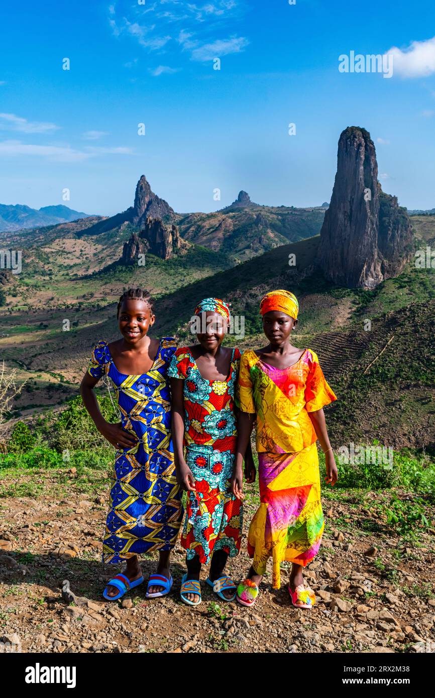 Three Kapsiki tribal girls in front of the lunar landscape of Rhumsiki ...